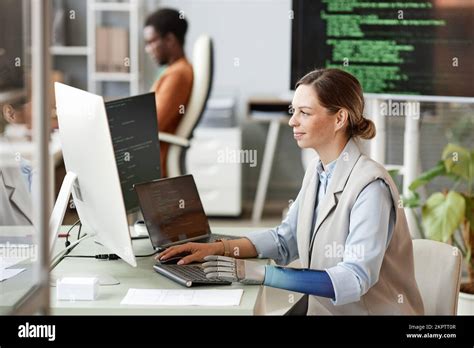 Smiling Woman With Bionic Arm Coding On Computer When Working On Big