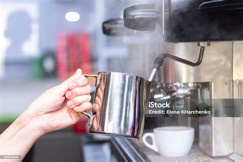 스팀 에스프레소 커피 머신에서 커피를 준비하는 커피숍 직원 커피 머신의 증기와 금속 주전자에 바리스타 온난화 우유 갈색에 대한