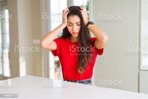 흰색 테이블에 집에서 젊은 아름 다운 여자는 두통 필사적으로 고통을 고통 및 편두통 때문에 스트레스 머리에 손을 갈색 머리에 대한 스톡 사진 및 기타 이미지 Istock