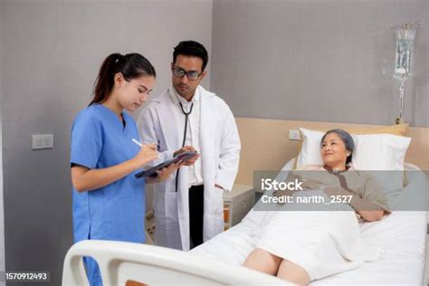 전문 의사와 간호사가 병원에 있는 노인 환자 의료 및 병자 태블릿에 의료 및 건강 관리를 보고하여 진단 질병 노인 및 몸이 좋지 않은 환자를 설명하고 확인합니다 3 명에