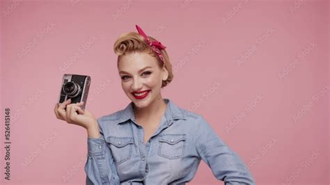 Pretty Pin Up Blond Girl Look At The Camera Hold Camera In Hand And