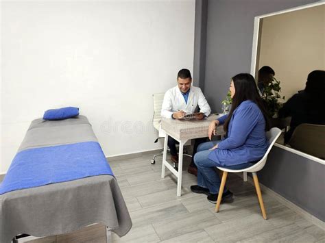 Dark Skinned Male Specialist Doctor Attends To Female Patient In