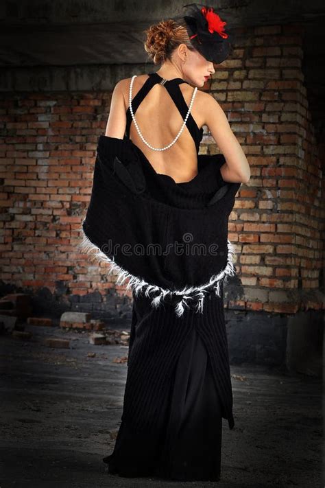 Элегантная женщина в черных платье и шляпе с вуалью Стоковое Изображение изображение