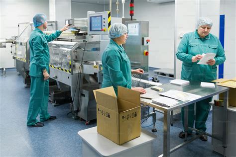 제약 기술자는 제약 공장의 멸균 작업 조건에서 작업합니다 보호 복을 입은 과학자 사진 Unsplash의 개념 이미지