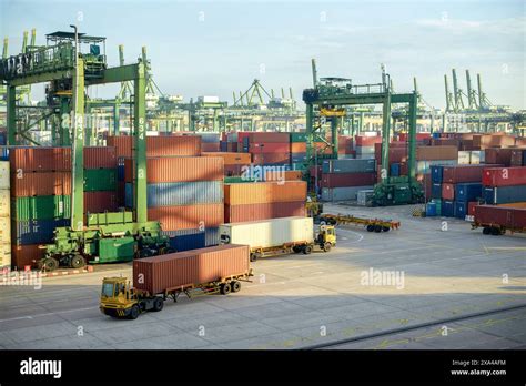 A Bustling Container Terminal With Stacks Of Multicolored Shipping Containers Cranes Towering