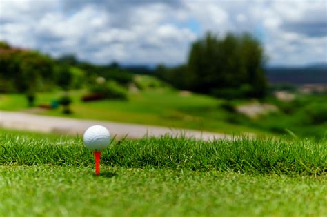 맑은 날의 푸른 하늘 및 구름의 관점과 산 배경으로 푸른 잔디에 오렌지 티에 흰색 골프 공을 닫습니다 텍스트에 대 한 공간을 복사 합니다 경쟁에 대한 스톡 사진 및 기타