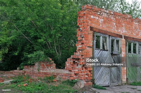 화창한 여름 날에 깨진 벽돌 벽 배경입니다 추상적 인 빨간 벽돌 오래된 벽 텍스처 배경입니다 고르지 않은 붉은 벽돌 벽을 무너뜨리는 유적 벽에 있는 오래된 문 0명에 대한