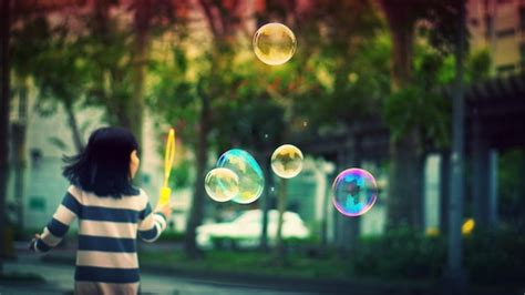 Premium Photo Rear View Of Girl Blowing Bubbles At Park