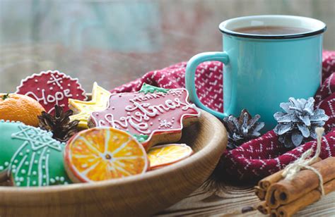 뜨거운 차 한 잔이 나무 접시 옆에 있는 나무 테이블에 서 있는데 나무 판 옆에는 물방울이 있는 창문 배경에 오렌지 조각으로 만든 진저브레드 쿠키가 있습니다 10월에 대한