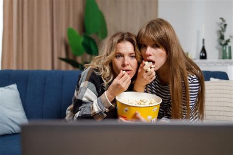 Deux Femmes D Ges Diff Rents Regardent Un Film D Horreur Et Mangent Du Pop Corn Photo Premium