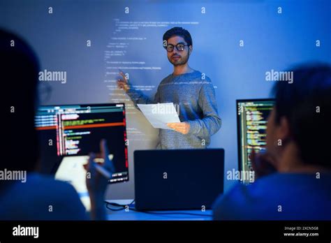 Asian Developer Leads Present Code Review Session Pointing At Code