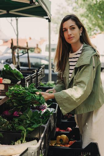 시장에 여성 파머스 마켓 마구간에서 쇼핑하는 성숙한 여성 고객 현지 파머스 마켓에서 쇼핑하는 여성 아름 다운 여자가 야채를 사 닫습니다 시리즈의 일부 건강한 생활방식에 대한