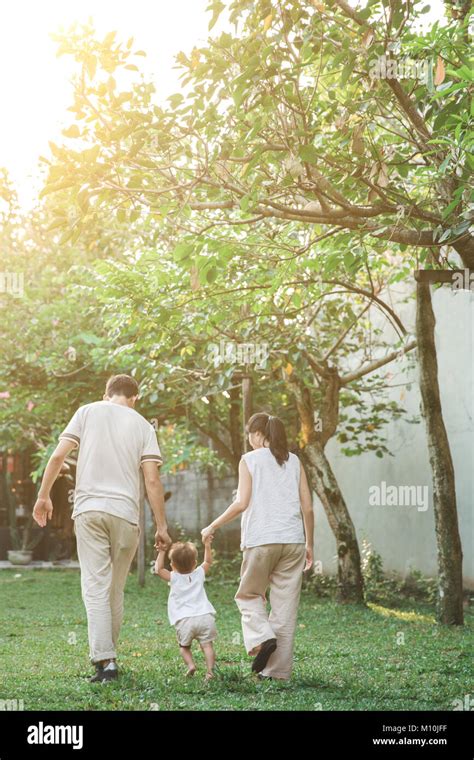 Parent With Their Cute Baby Walking Together In The Park Stock Photo Alamy