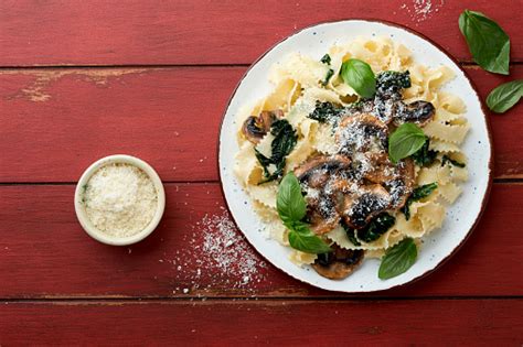 크리미 알프레도 파스타 버섯 닭고기 시금치 바질 크림 소스를 곁들인 이탈리아 파스타 페투치니가 붉고 소박한 테이블 배경에 있다 전통적인 이탈리아 요리 플랫 레이 복사 공간