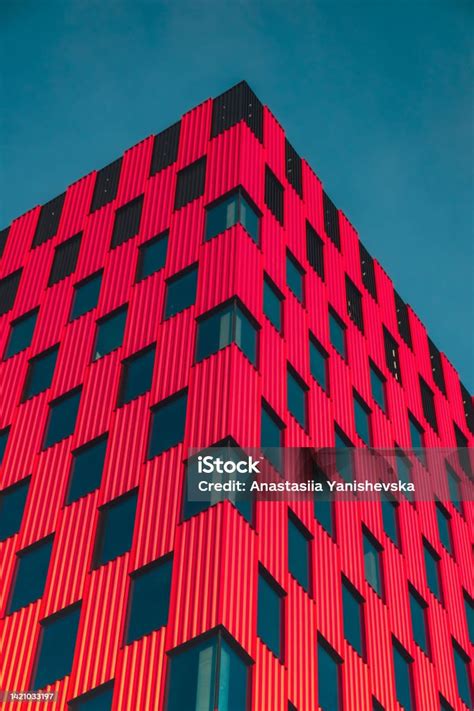맑은 하늘 배경에 유리 외관이있는 현대적인 사무실 건물 외관 생생한 색상 빨간색 분홍색 장식으로 사무실 건물의 투명한 유리 벽 현대 유럽 건물 상업 사무실 건물의 외관의