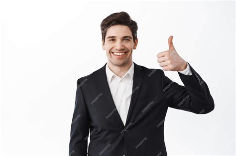 Красивый бизнесмен деловой человек улыбается показывает палец вверх и одобрительно кивает