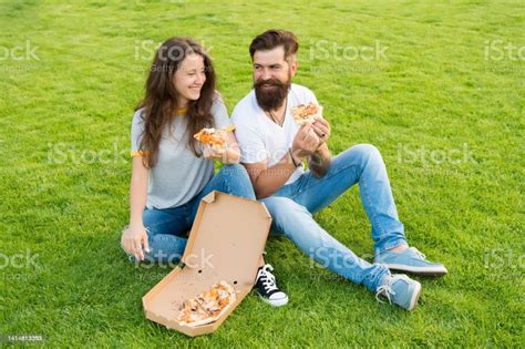 패스트 푸드 배달 수염을 가진 남자와 여자는 치즈 피자를 즐깁니다 피자와 함께 야외에서 데이트하는 것을 좋아하는 커플 배고픈