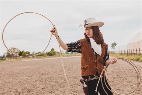 Premium Photo Cowgirl Throwing Lasso While Standing At Ranch Against Sky
