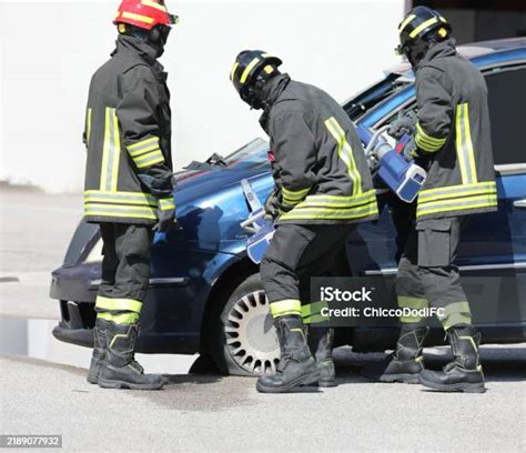 자동차 사고와 관련된 자동차의 금속을 절단하기 위해 유압 턱을 사용하는 소방관 3 명에 대한 스톡 사진 및 기타 이미지 3