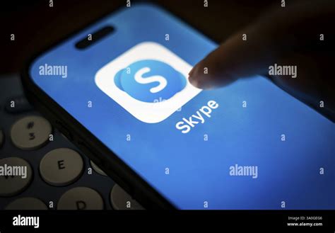 In This Photo Illustration A Person Holds A Mobile Phone Displaying Skype Application In