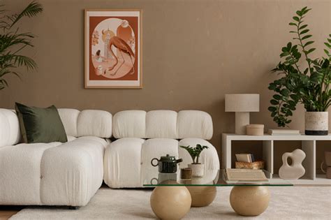 녹색 식물 모형 포스터 프레임 예술 Boucle 소파 세련된 커피 테이블 패턴 깔개 대리석 램프 및 개인 액세서리가있는 거실