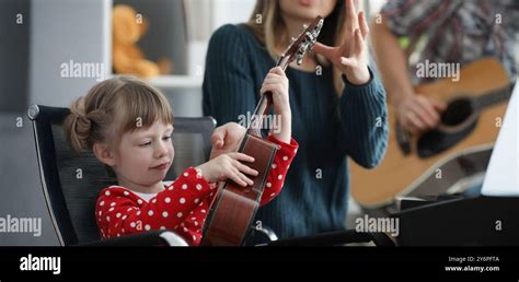 Mother Take Musical Instrument From Daughter Hands To Show How To Play