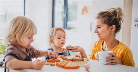 두 명의 어린 자녀를 둔 어머니는 침실에서 나무 장난감을 가지고 놀고 있습니다 사진 Unsplash의 어머니와 아들 이미지