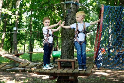 Two Little Friends Say Hello While Passing The Tests In The Rope Park