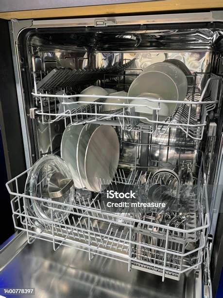 플라스틱이 든 식기 세척기의 내부 이미지 깨끗한 스테인레스 스틸 나이프 포크 및 숟가락이 들어있는 식기 바구니 씻고 말린 후 버릴 수있는 깨끗한 도구가있는 반 전체 기계