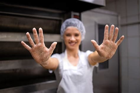 하얀 유니폼을 입은 여성 베이커의 초상화와 베이커리 생산에서 베이킹 오븐으로 밀가루로 덮인 손을 보여주는 헤어넷 밀가루에 대한 스톡 사진 및 기타 이미지 Istock