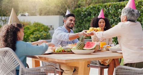 생일 파티 음식 및 집에서 축하 감사 및 사랑을 위해 야외 파티오 또는 테이블에서 가족 식사 부모 자녀 및 노인이 여름 점심 또는 건강한 과일을 곁들인 브런치를 위해