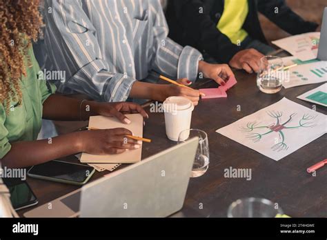 A Group Of Professionals Gather Around A Table Engaging In A