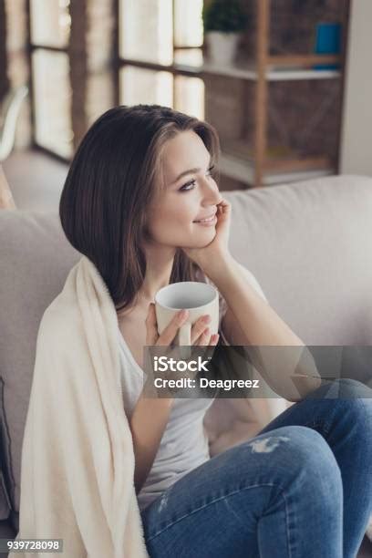 격자 무늬에서 소파에 앉아서 커피를 마시는 아주 젊은 여자의 초상화 담요에 대한 스톡 사진 및 기타 이미지 담요 소파