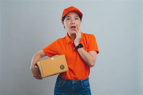 유니폼 폴로 티셔츠를 입고 상자를 들고 있는 아시아 여성은 하얀 배경 위에 고립되어 서 있다 T 셔츠에 대한 스톡 사진 및 기타 이미지 Istock