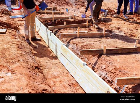 Workers Are Assembling Wooden Forms For Foundation Of New Structure At