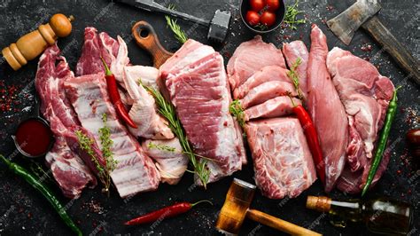 Premium Photo Raw Meat Background Meat On A Black Stone Background With Spices And Herbs Top