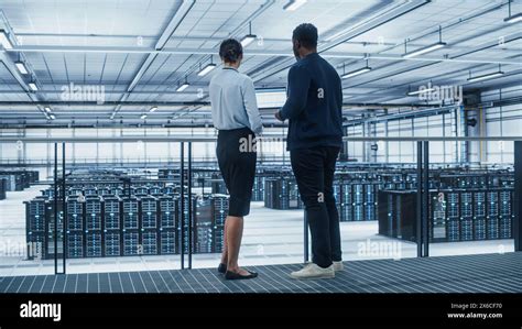 Data Center Female System Administrator And Male It Specialist Talk