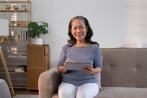 집에서 여가 시간에 디지털 태블릿을 사용하는 아름다운 나이든 아시아 여성 남자에 대한 스톡 사진 및 기타 이미지 남자 노인 노트북 Istock