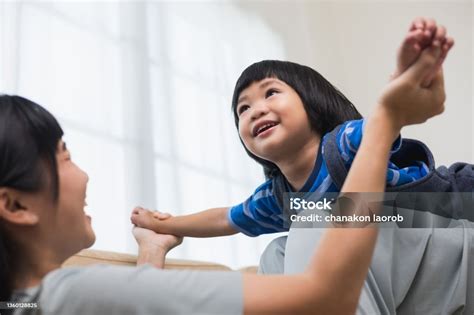 거짓말 비행기를 재생 긍정적 인 어린 소년은 행복한 어머니와 거실에서 소파에 비행 엄마와 아들은 주말에 집에서 가족 시간을 즐기는 재미를 가지고 있습니다 2명에 대한 스톡