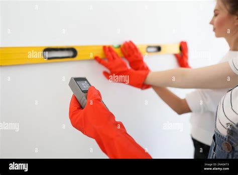 Laser Rangefinder Or Laser Tape Measure In A Female Hand Smart Device For Quick Measurement Of