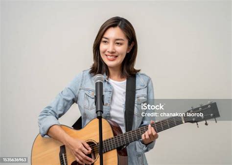 행복 젊은 아시아 여자는 기타와 함께 노래를 부른다 고립된 배경에 있는 아티스트 보컬리스트 가수 자신감 넘치는 여성 대중 연설이