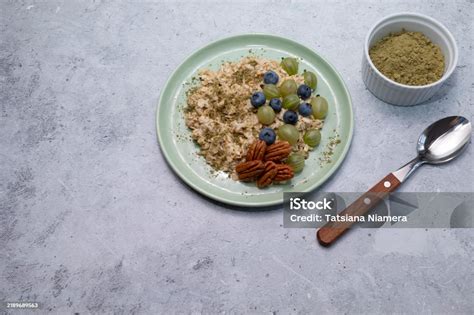 슈퍼푸드 건강한 아침 식사 대마 단백질 분말 견과류 딸기 대마초 식물에서 추출한 식물 유래 단백질이 담긴 그릇 숟가락을 곁들인 오트밀 죽 공간 복사를 클릭합니다 식사 평면