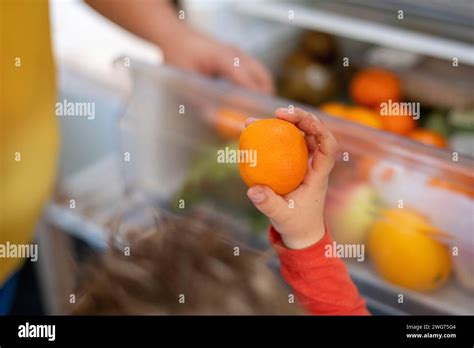 Mother Giving Her Son A Healthy Snack Fruit From The Fridge Stock