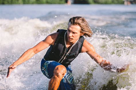 아름다운 긴 머리 금발 웨이크 서핑 호수의 파도를 따라 보드에 조끼 육상 남성 선수는 강에서 여름에 서핑을 깨워 웨이크 서핑 수상 스포츠 파도에 서퍼 서핑보드에서 서핑하는