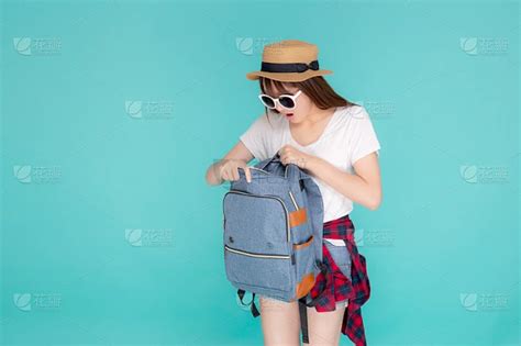 美丽的肖像年轻的亚洲女人戴墨镜和帽子打开背包和惊喜旅行夏季旅行假期在假期孤立的蓝色背景，旅游女孩兴奋素材 花瓣网