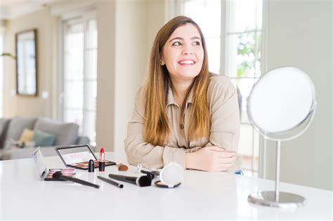 화장 화장품을 사용 하 여 아름 다운 젊은 여자는 얼굴에 미소와 함께 옆으로 찾고 자연스러운 표정 자신감 있게 웃고 있습니다 가정 생활에 대한 스톡 사진 및 기타 이미지