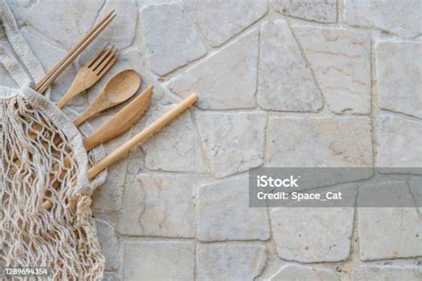 돌 배경에 메쉬 토트 백에 소재한 천연 나무 칼붙이 재사용 가능한 친환경 주방 제품 제로 폐기물과 지속 가능한 플라스틱 없는 라이프 스타일 가방에 대한 스톡 사진 및 기타