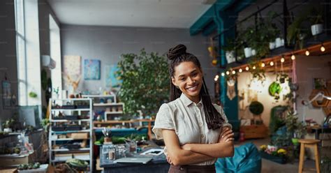 그녀의 작업장에서 팔짱을 끼고 서 있는 웃고 즐겁고 유쾌한 꽃 디자이너의 정면 모습 사진 Unsplash의 청년 성인 이미지