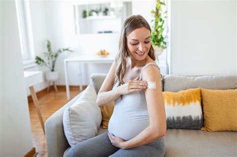 임신 중 코로나바이러스 예방 접종 코로나바이러스 백신 주사 후 포즈를 취한 석고 스트립으로 예방 접종 팔을 보여주는 즐거운 임산부 코로나 바이러스 예방 접종 30 34세에