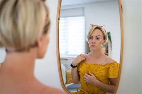 노란 드레스를 입은 여자가 드레스를 조정하면서 거울에 비친 자신을 관찰하고 있다 개성 개념에 대한 스톡 사진 및 기타 이미지 개성 개념 거울 한 명의 여자만 Istock